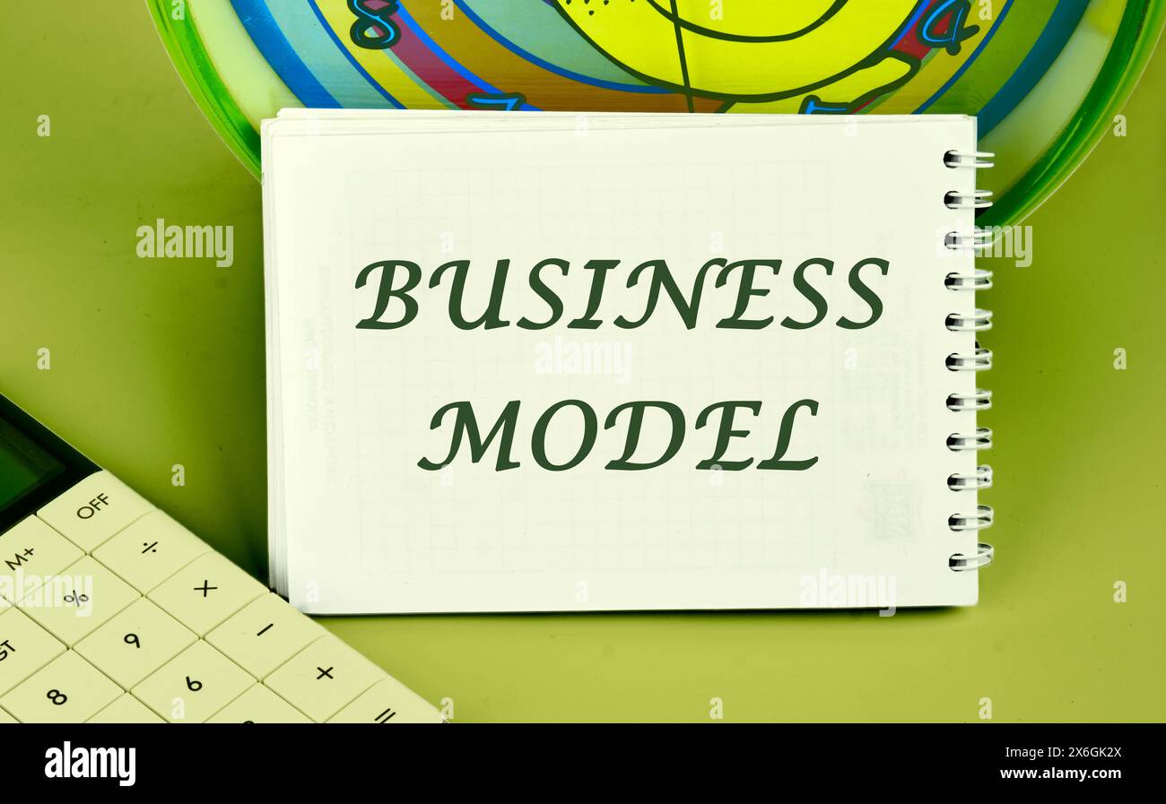 BUSINESS MODEL text on a notepad on the background of a clock next to a ...