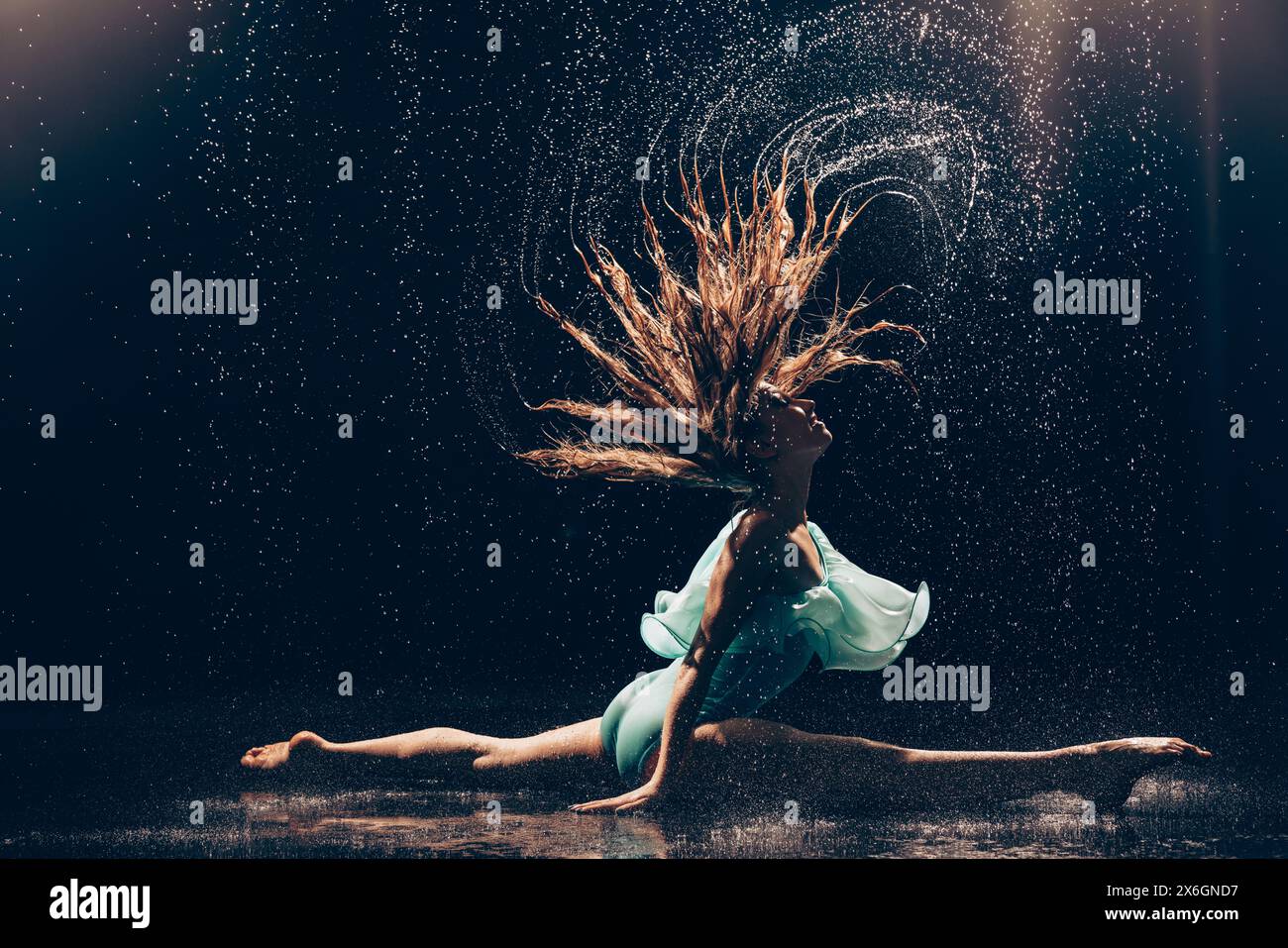 Ballerina teenager girl in green bodysuit performing gymnastic splits ...