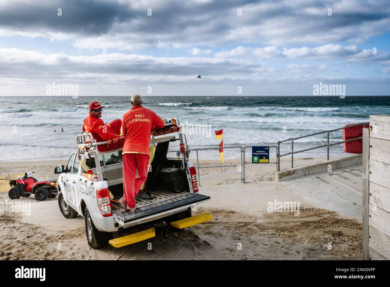 Two RNLI Lifeguards on their emergency response vehicle on duty at ...
