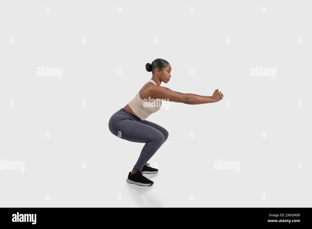 Woman Performing Squat Exercise on White Background, Side View Stock ...