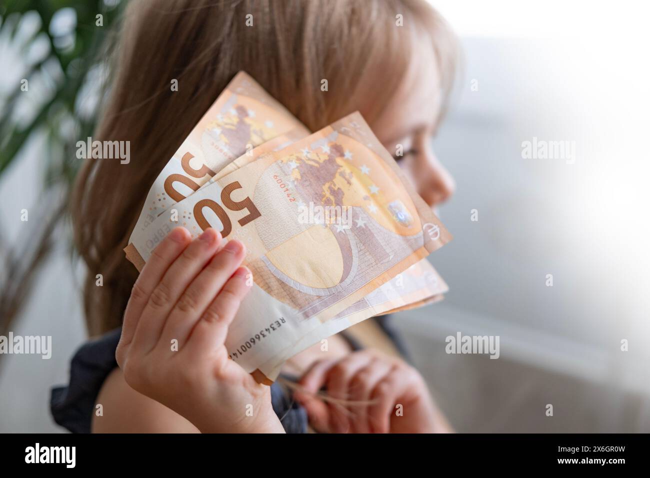 female child, girl holds 50 euro banknotes close-up, dreams and ...