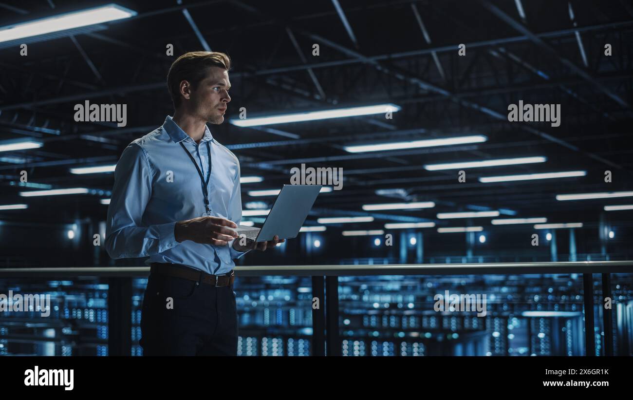 Data Center Specialist Engineer Using Laptop Computer. Server Farm Cloud Computing Facility with ...