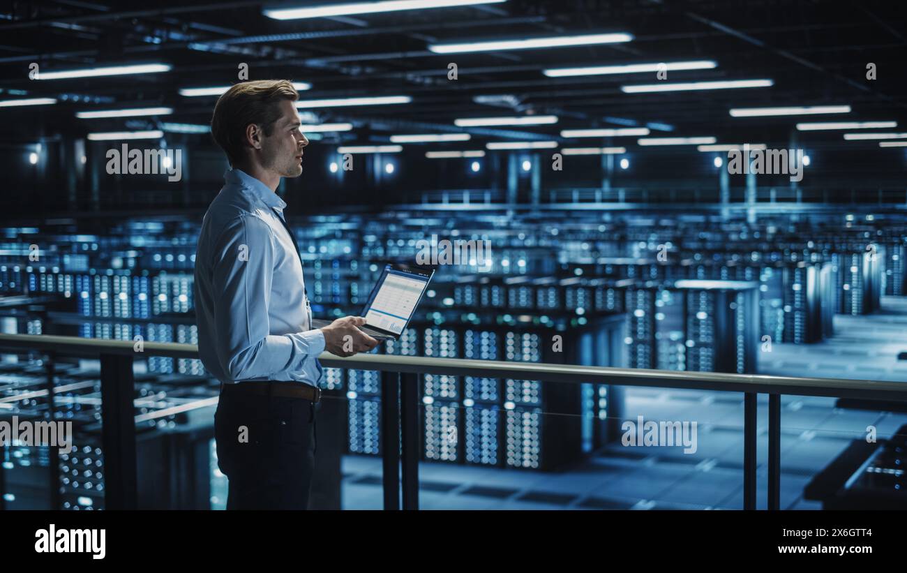 Data Center Specialist Engineer Using Laptop Computer. Server Farm ...