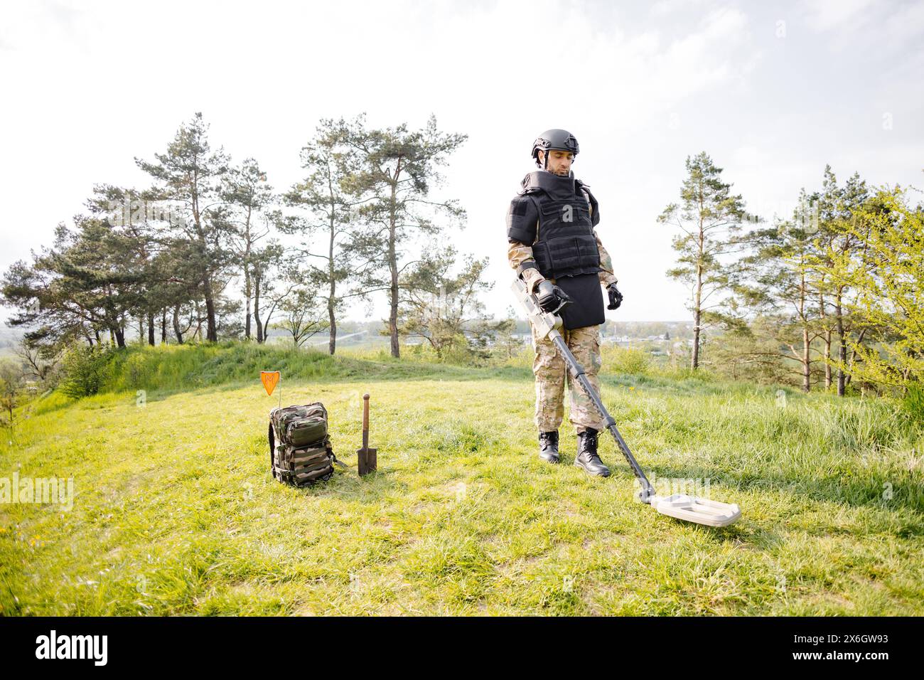 A man in a military uniform and bulletproof vest works in the forest ...