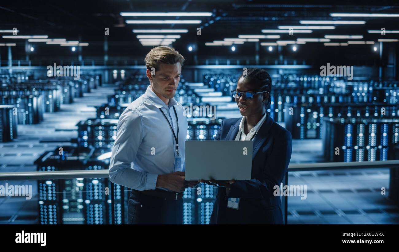 Data Center Female System Administrator and Male IT Specialist talk ...