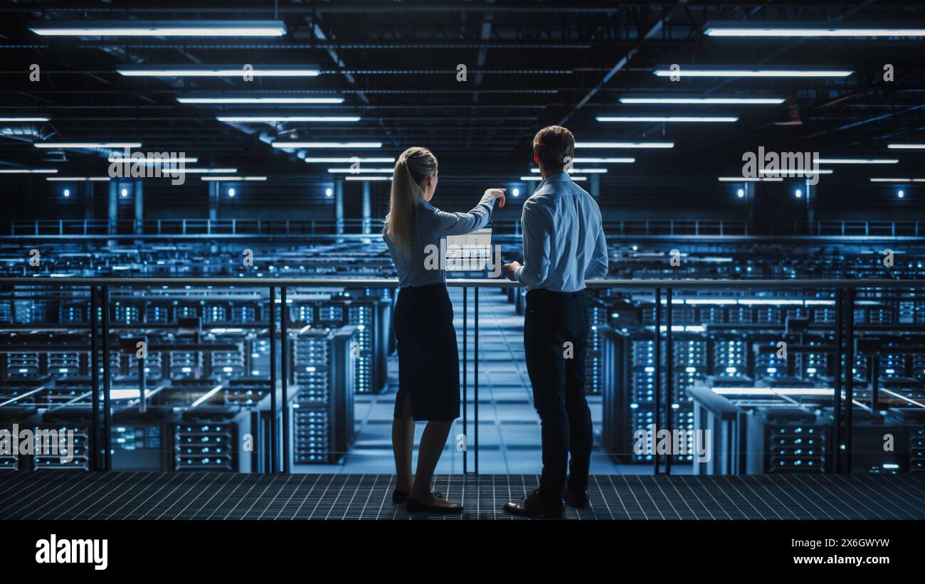 Data Center Male It Specialist and Female Maintenance administrator Talk, Use Laptop. Server ...