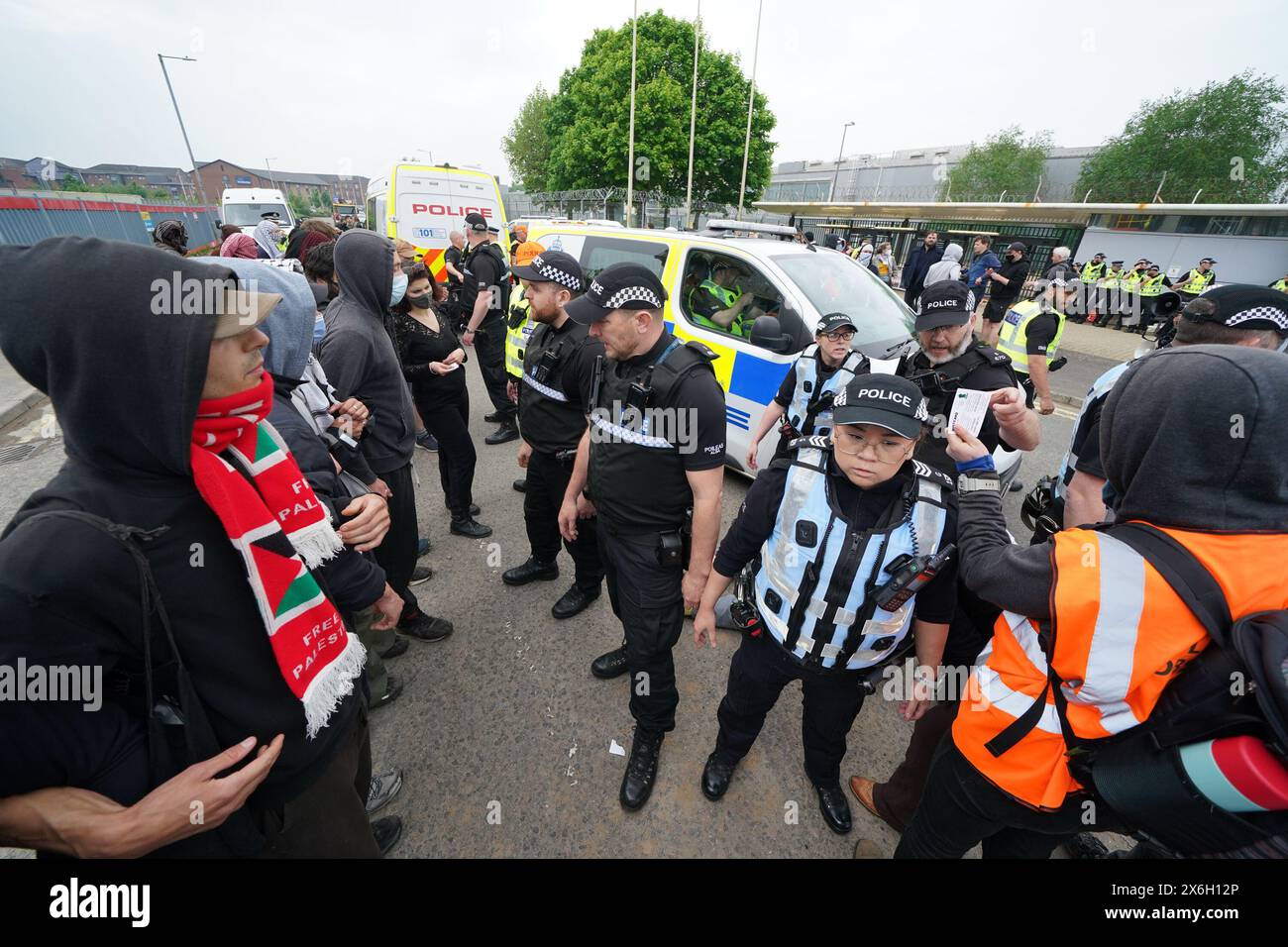 Police officers stand in front of pro-Palestine campaigners during a ...