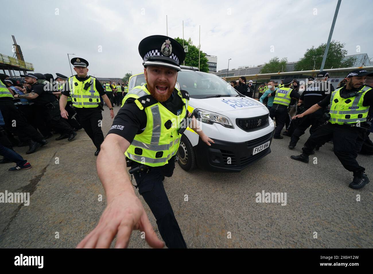 Police officers clear a path for a police vehicle during a protest by ...