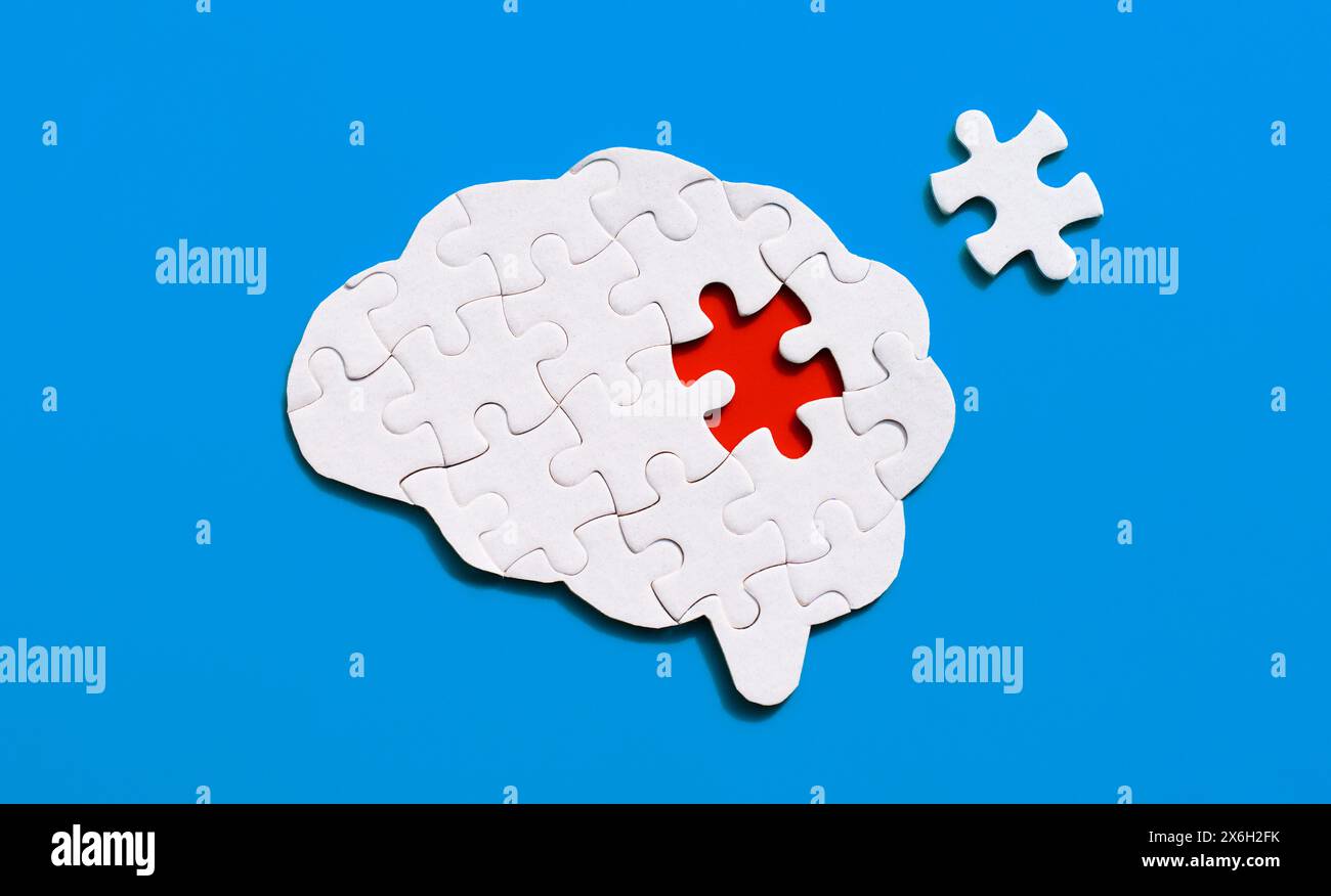 Brain-shaped puzzle with the missing piece, set against a gentle blue ...