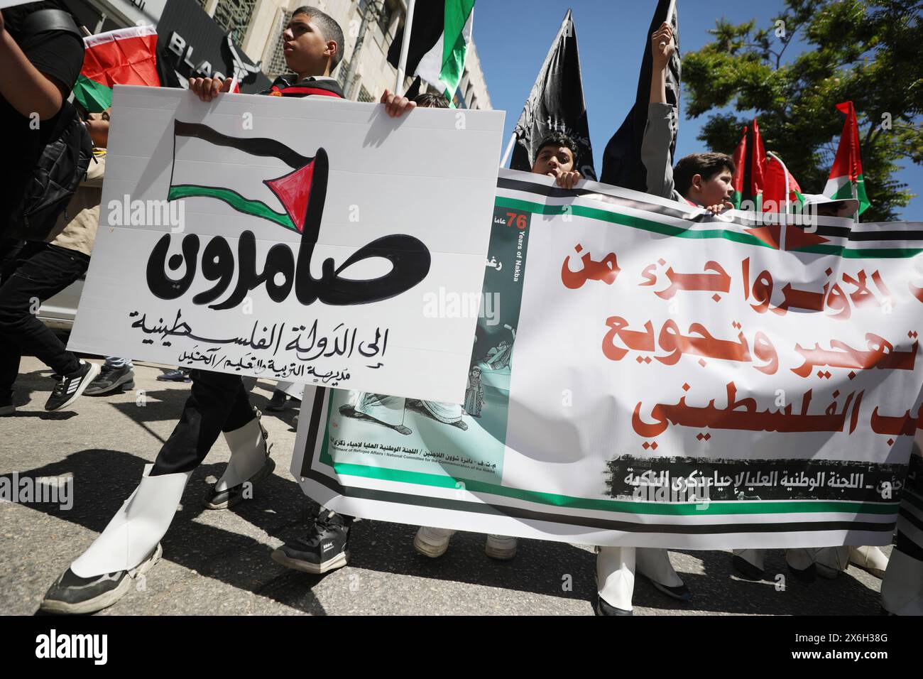 Palestinian youths hold national flags during a rally in the southern ...