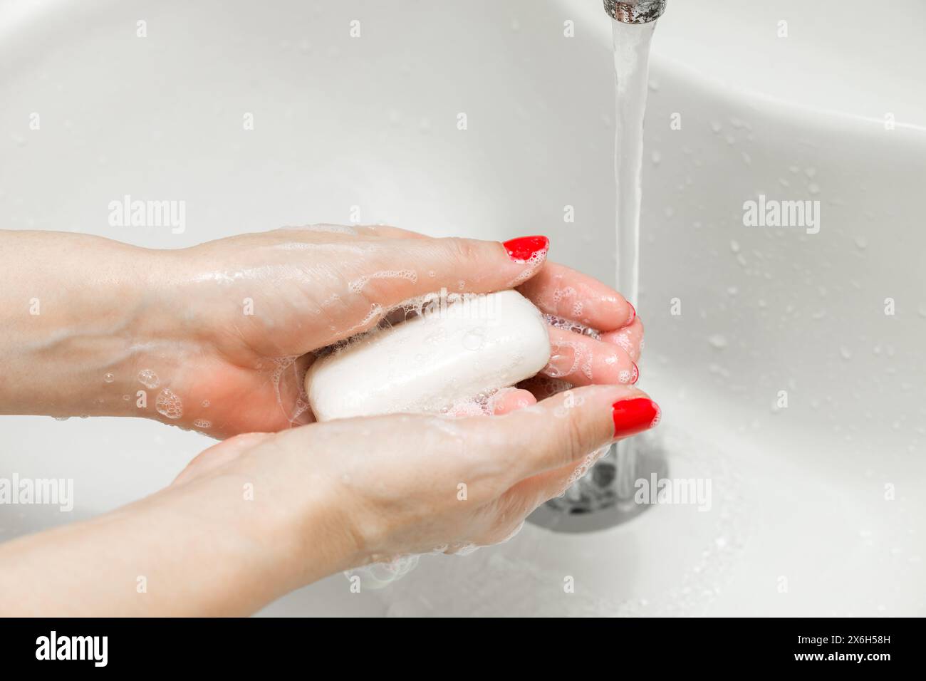 woman washing her hands with soap in the bathroom. hand soap. woman's ...