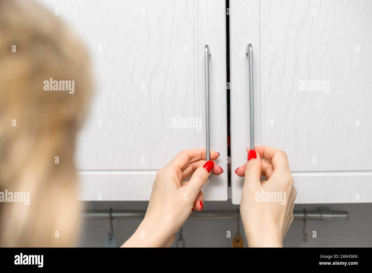 housewife opens kitchen cabinet doors with both hands, close-up. woman ...