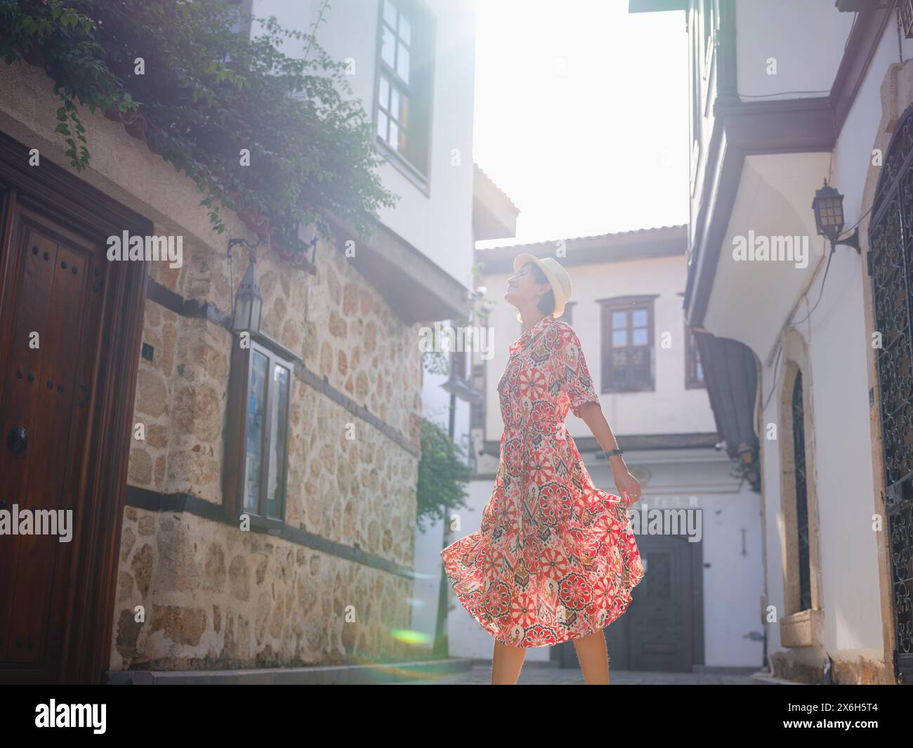 female summer travel to Antalya, Turkey. young asian woman in red dress walk through old town ...