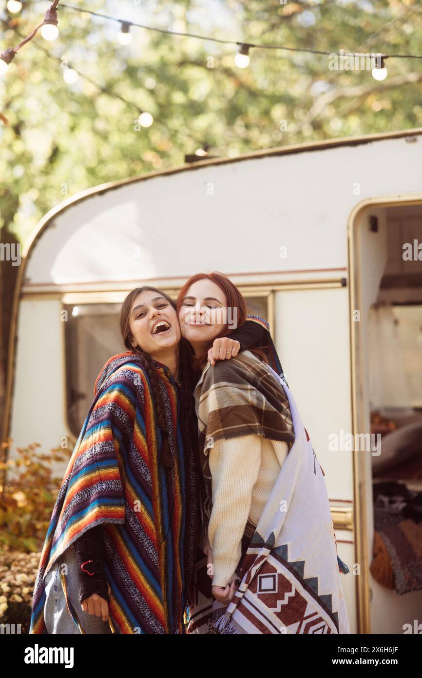 A duo of trendy girls flaunt their boho style against the trailer ...