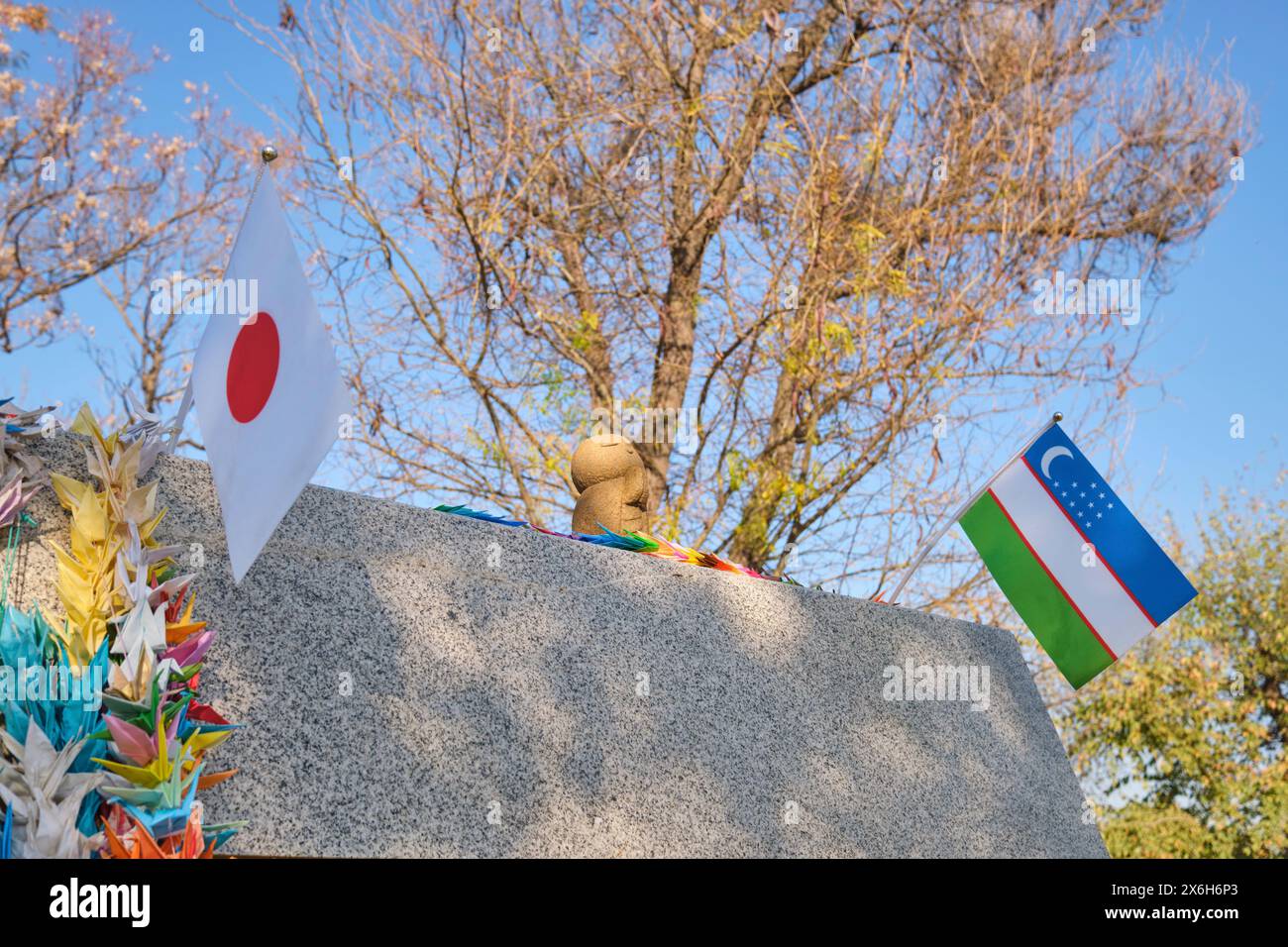 A stone, marker with traditional doll and flags. At the Japanese POW ...