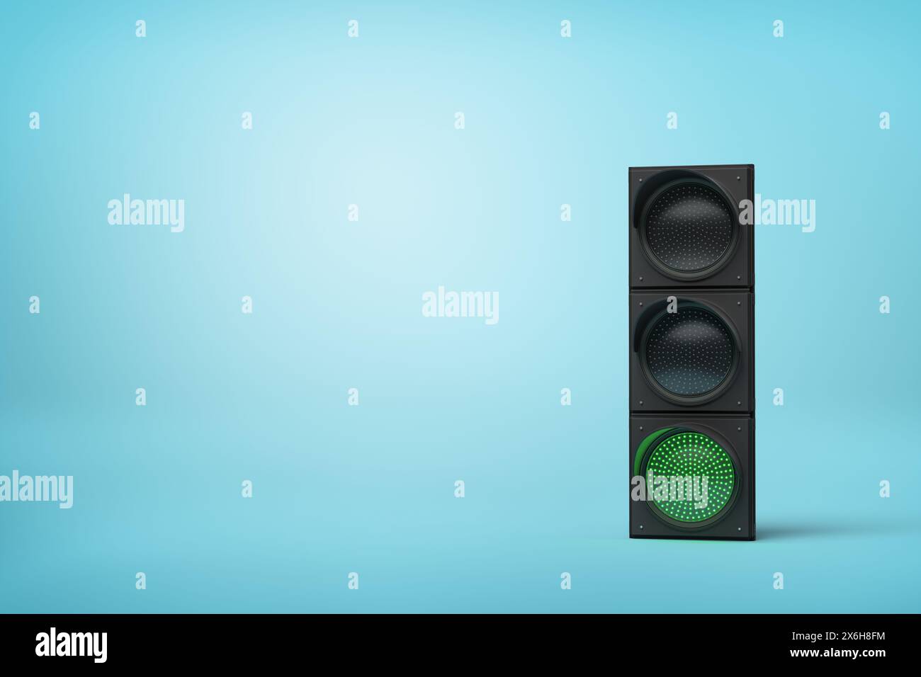 Green traffic light standing alone on blue background Stock Photo - Alamy