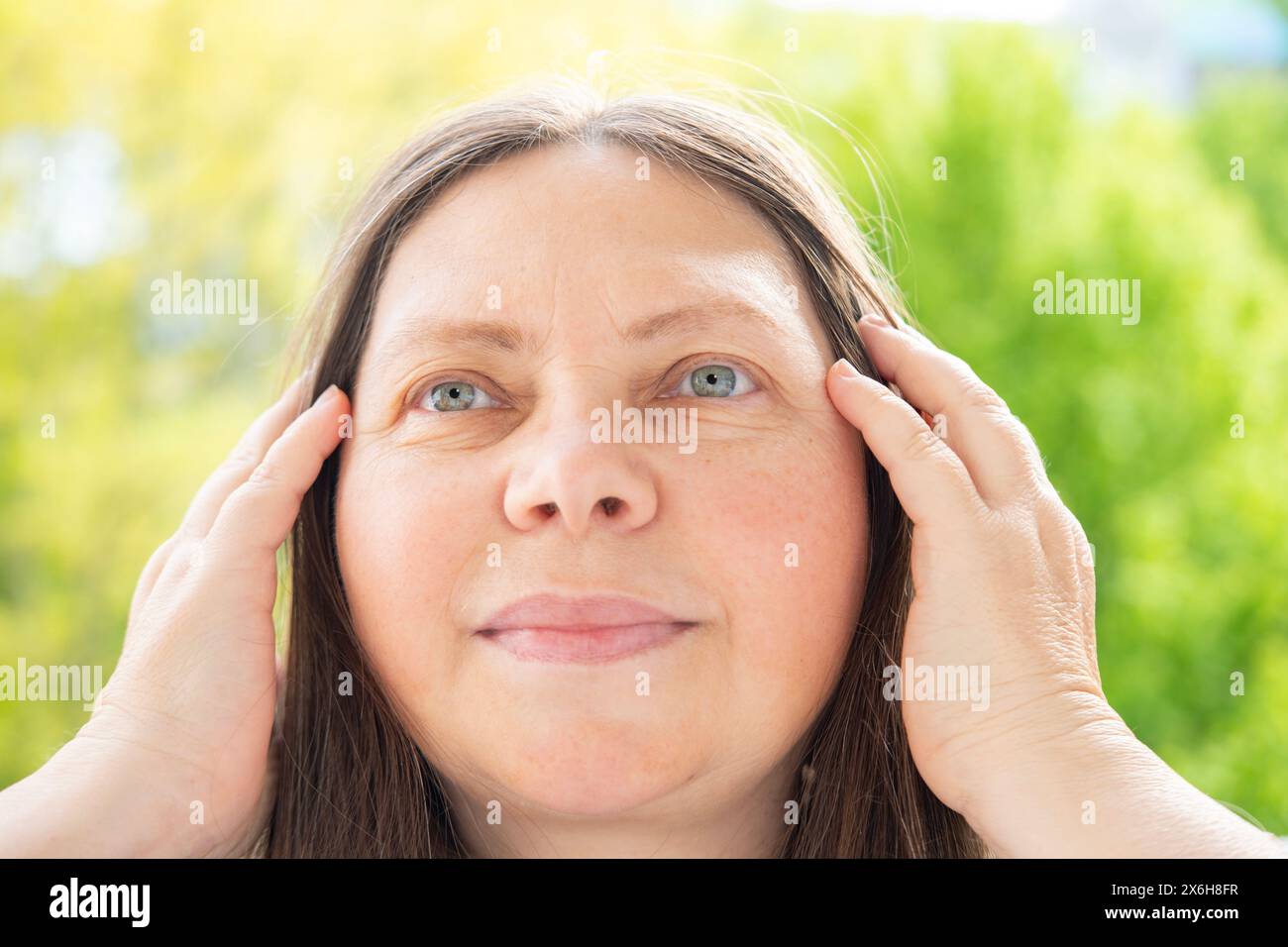 Caucasian positive 50-year-old attractive woman with long hair poses ...