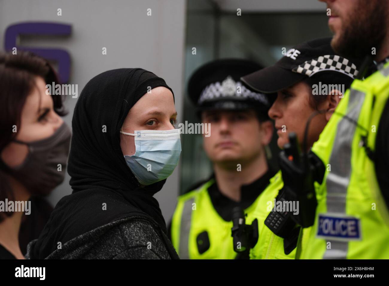 Pro-Palestine campaigners face police during a protest outside the ...