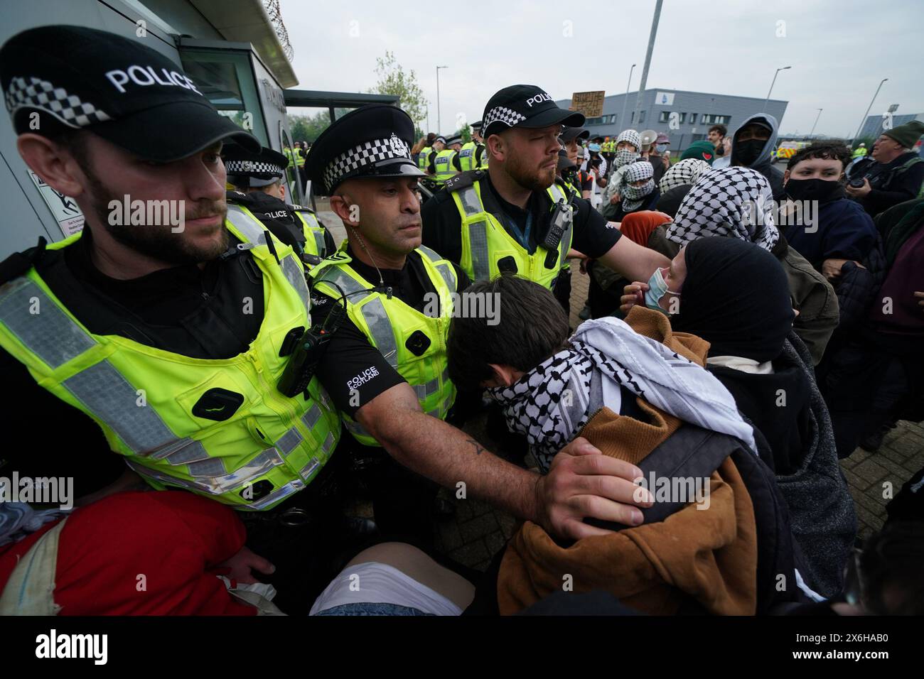 Police officers hold back pro-Palestine campaigners during a protest ...