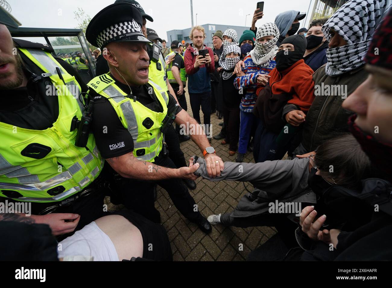 A police officer holds a pro-Palestine campaigner during a protest ...