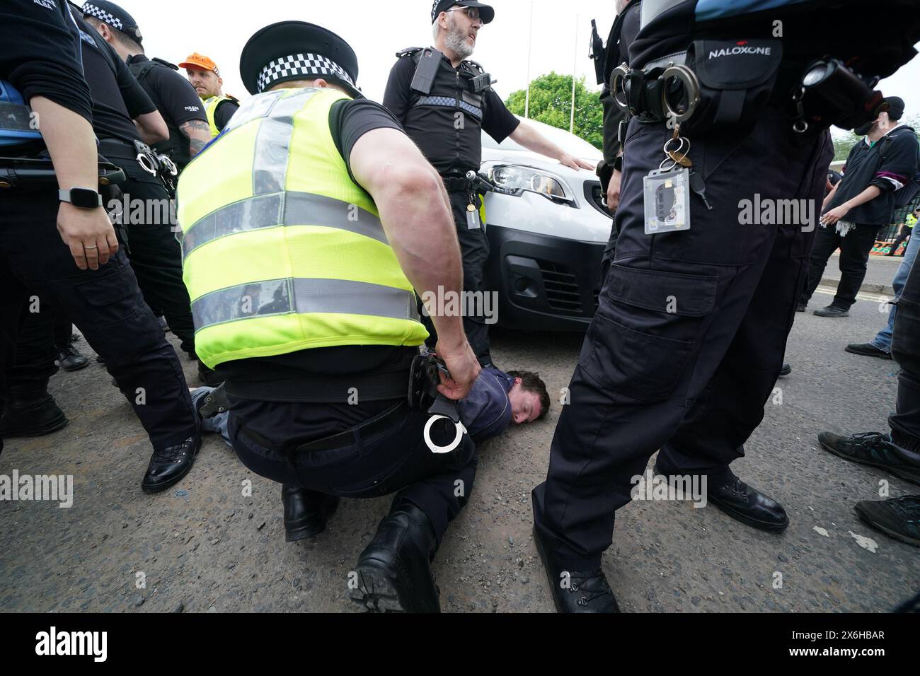 A pro-Palestine campaigner is held by police during a protest outside ...