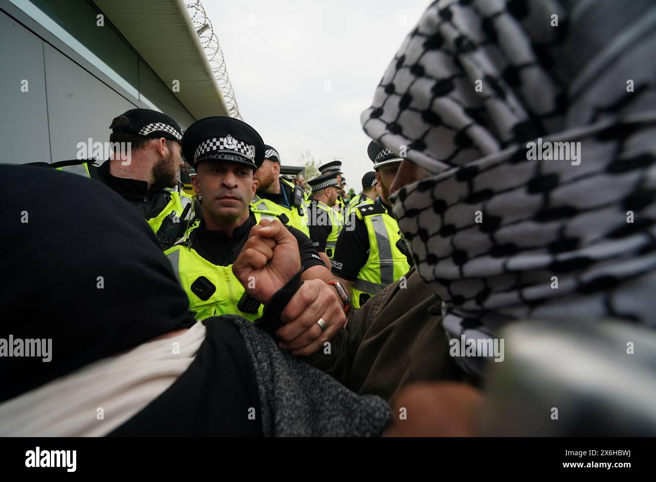 A police officer holds a pro-Palestine campaigner during a protest ...