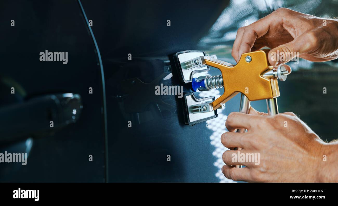 paintless car dent repair. man fixing vehicle door with PDR technology ...