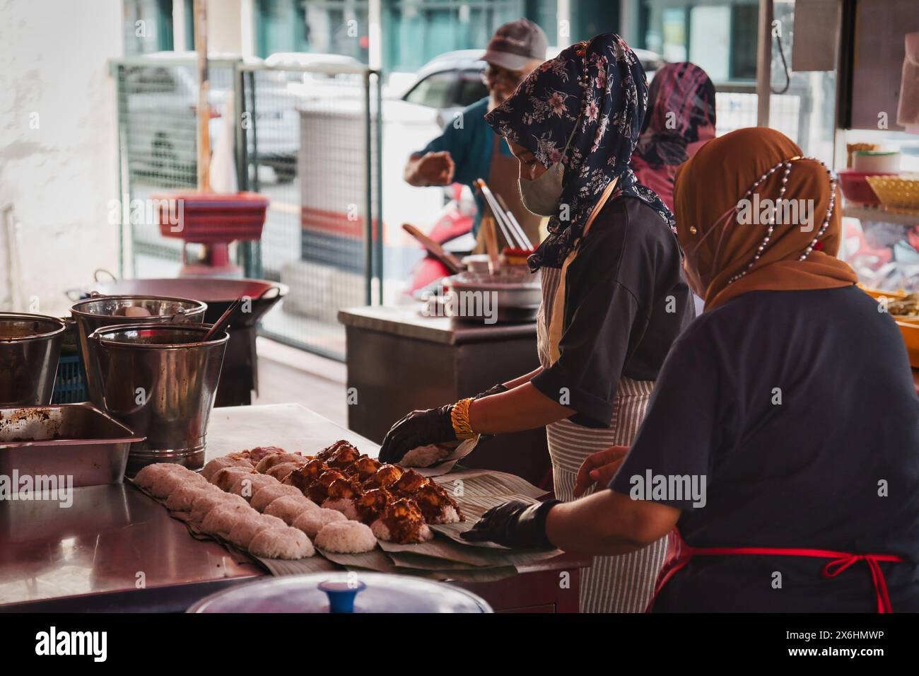 Penang, Malaysia - 1 November 2022: Malay hijab women prepares food at ...