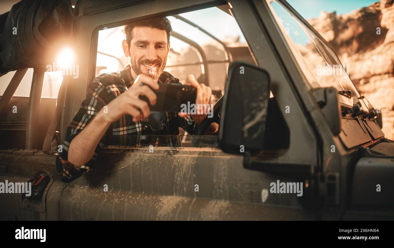 Desert Road Trip: Portrait of Male Explorer Using Smartphone to Take ...