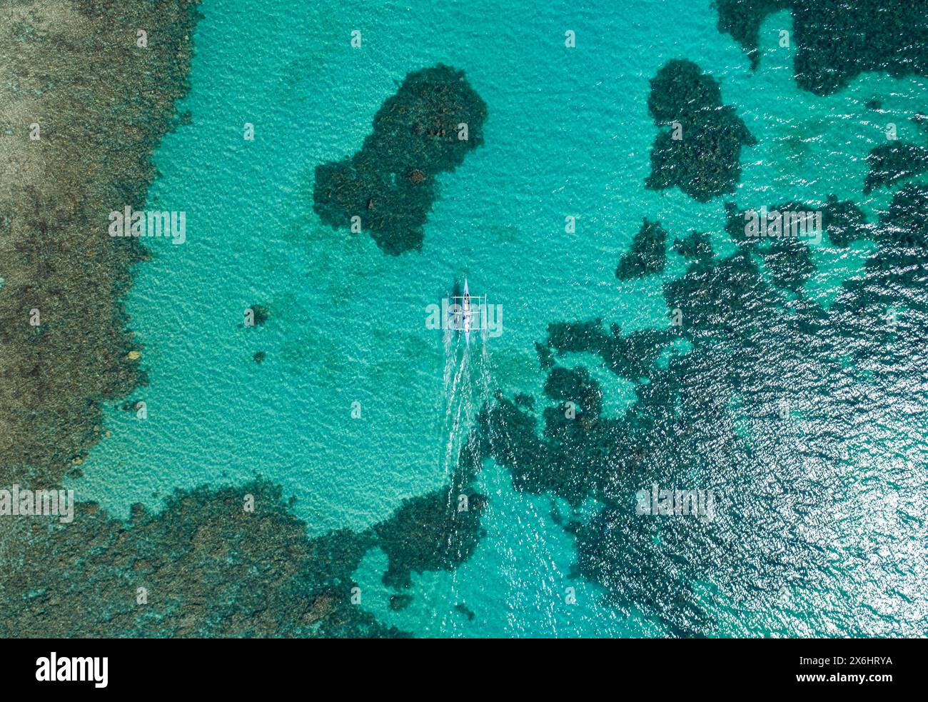 Aerial top view of Banca boat floating in open sea with clear and ...
