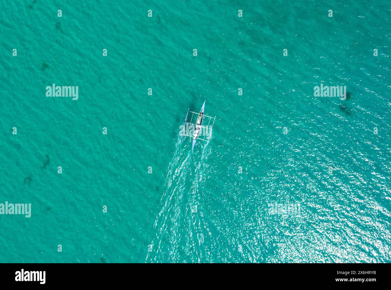 Aerial top view of Banca boat floating in open sea with clear and ...