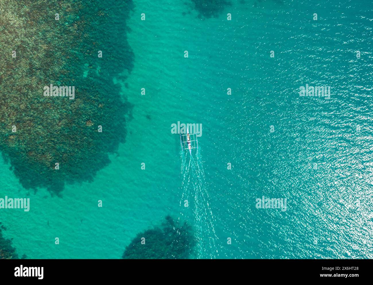 Aerial top view of Banca boat floating in open sea with clear and ...