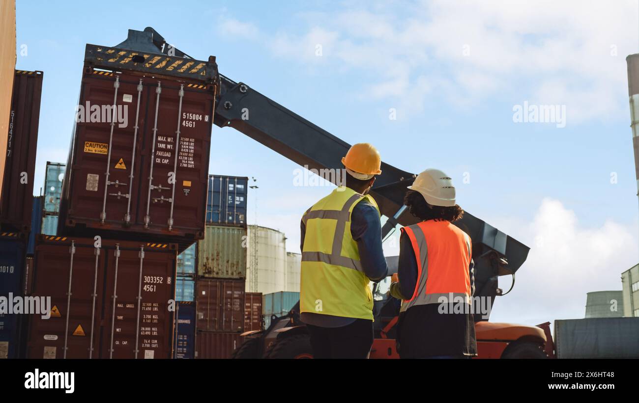 Multiethnic Female Industrial Engineer and Black African American Male Supervisor in Hard Hats ...