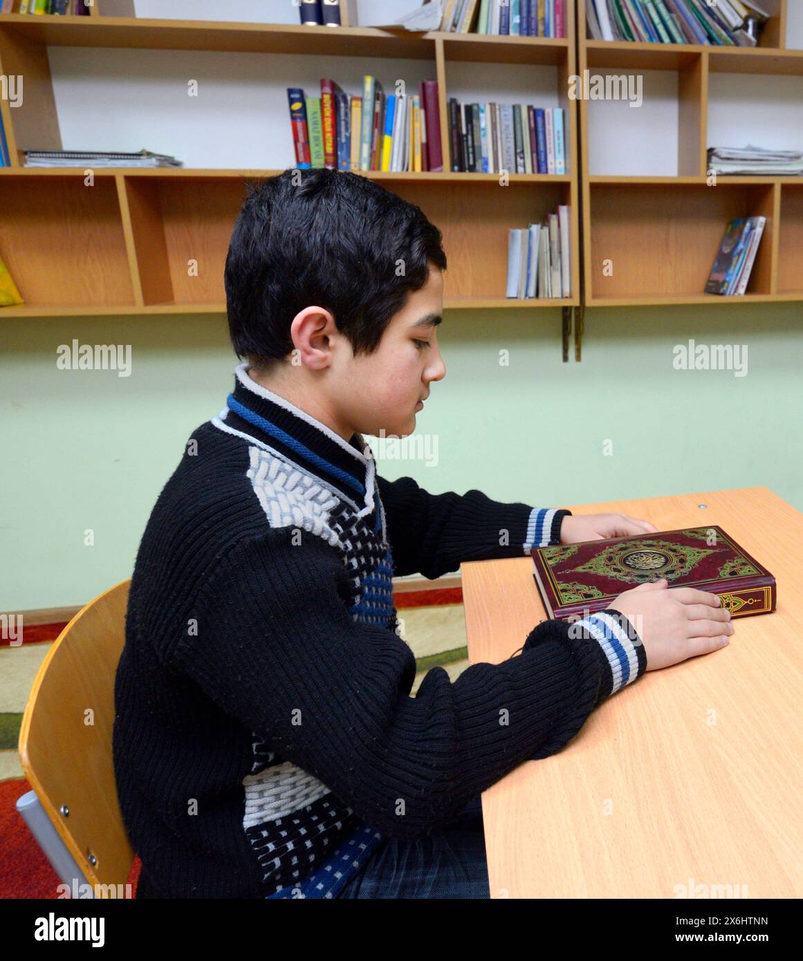 Classroom of the medrese. Muslim boy sitting at a school desk, Quran ...