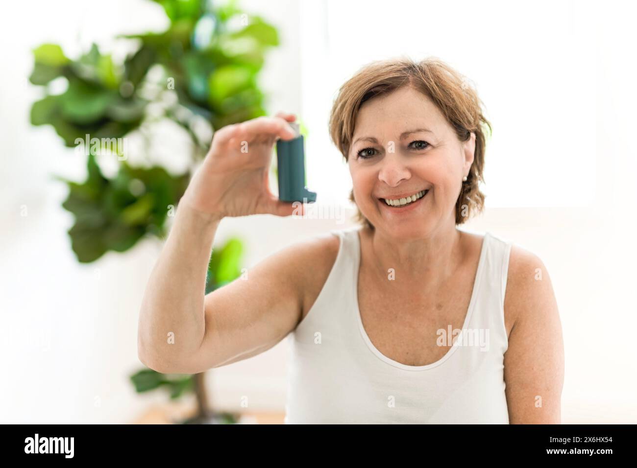 Elderly woman using asthma inhaler in clinic Stock Photo - Alamy