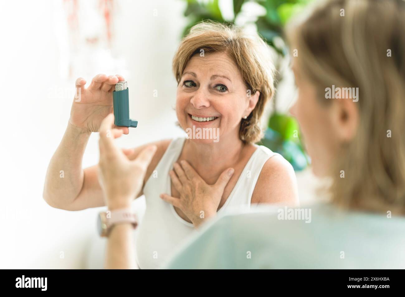 Elderly woman using asthma inhaler in clinic Stock Photo - Alamy