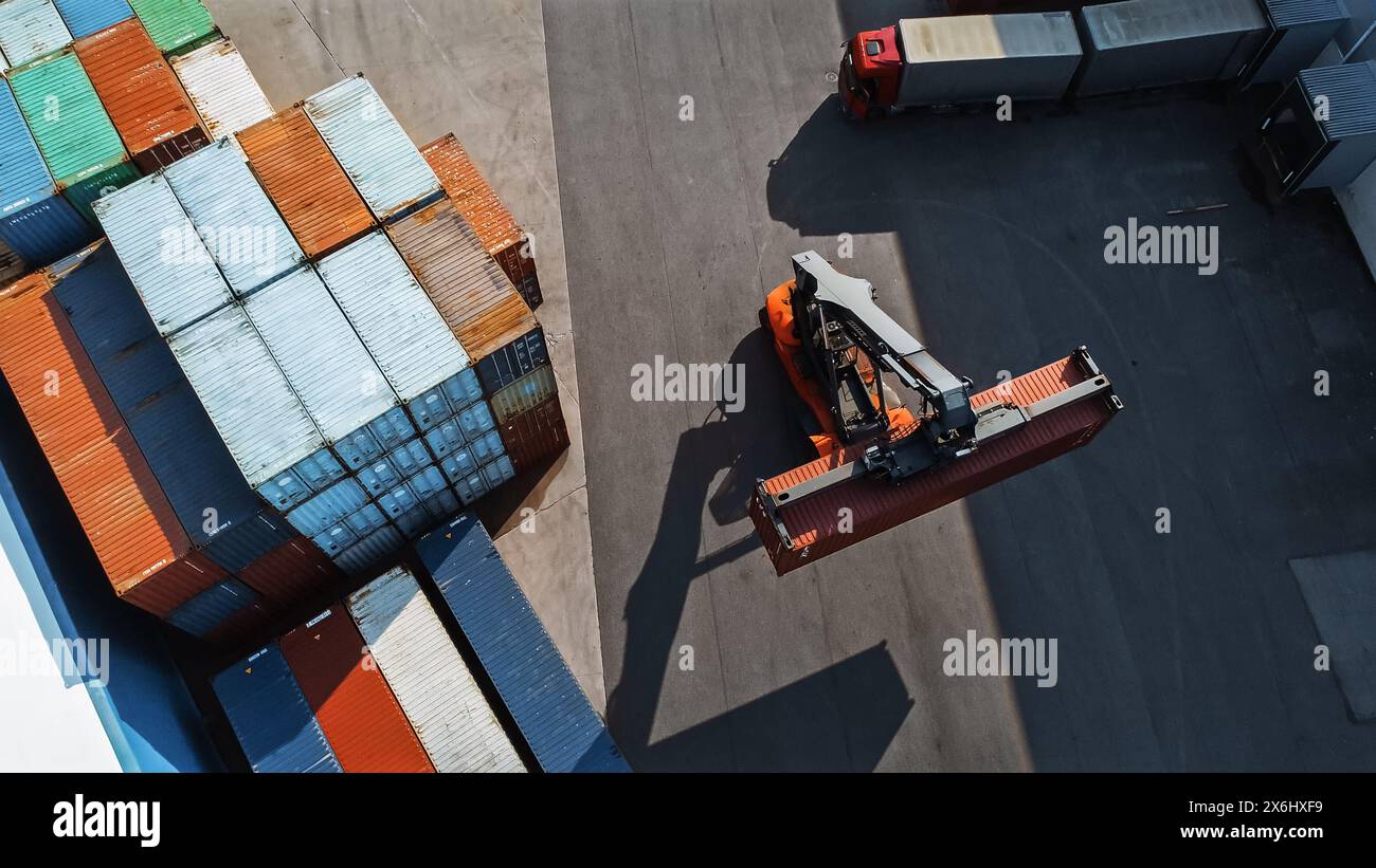 Aerial Top Down Shot of a Container Handler Carrying a Large Red Cargo ...