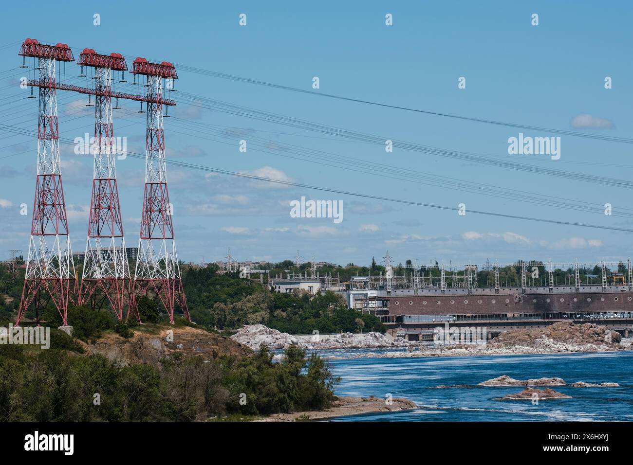 Hydroelectric power station by a river with high voltage power lines ...
