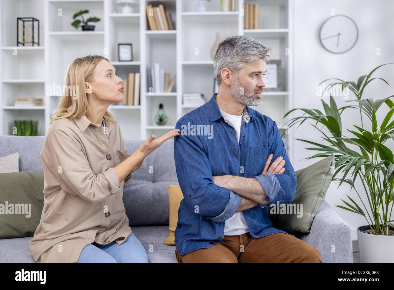 A couple engaged in a serious conversation at home, with the woman ...