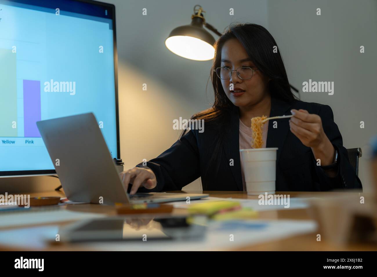 The woman ate instant noodles while working late at the office Stock ...