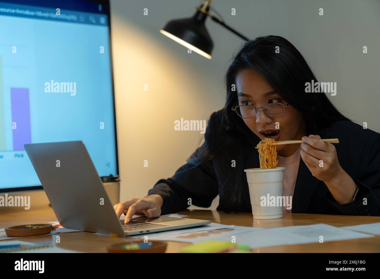 The woman ate instant noodles while working late at the office Stock ...