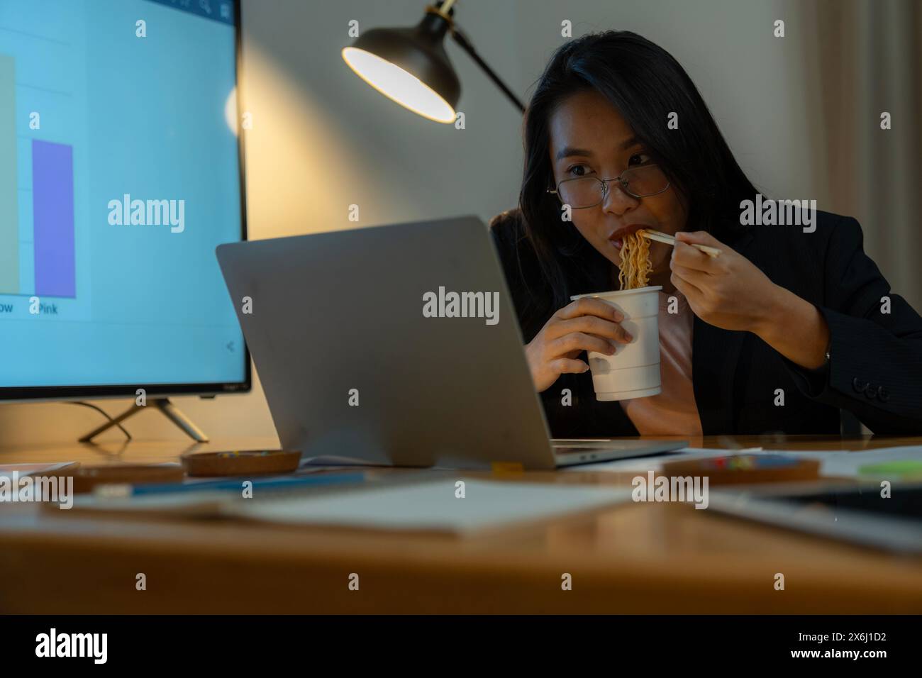The woman ate instant noodles while working late at the office Stock ...