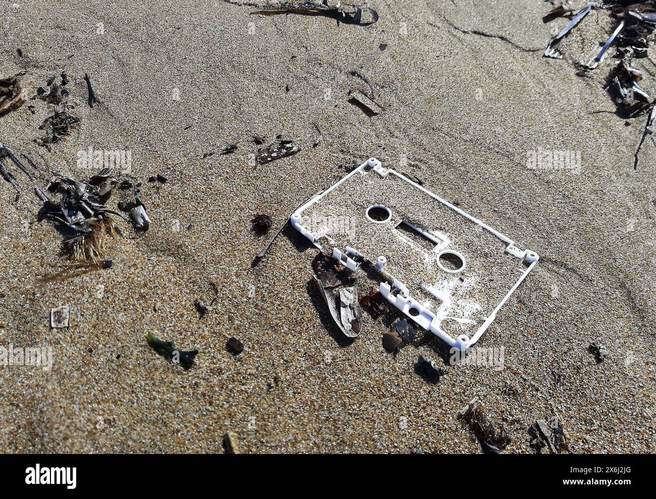 1980s plastic cassette tape frame on a sandy beach, highlighting ocean ...