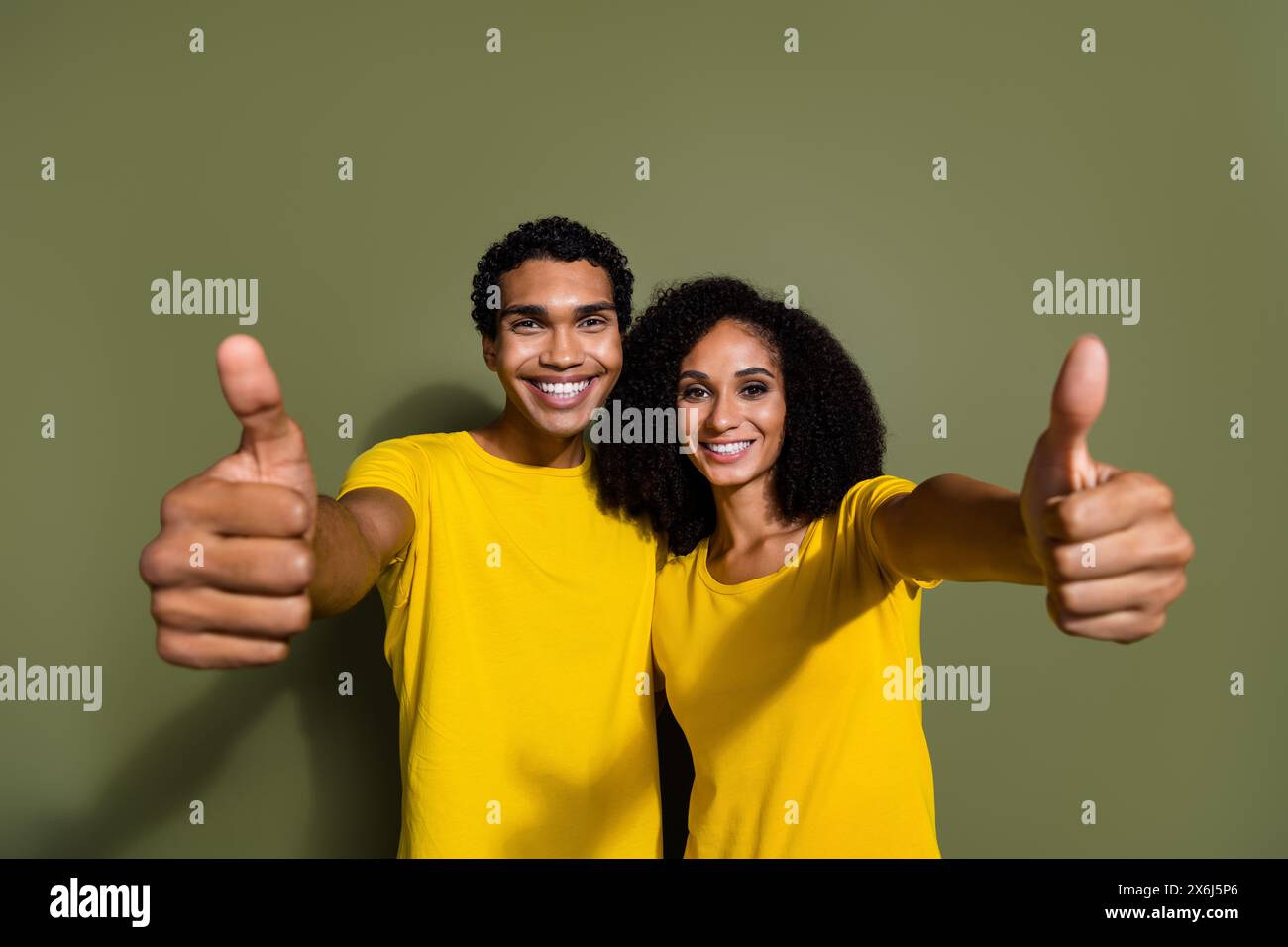 Portrait of two nice people show thumb up symbol wear t-shirt isolated ...