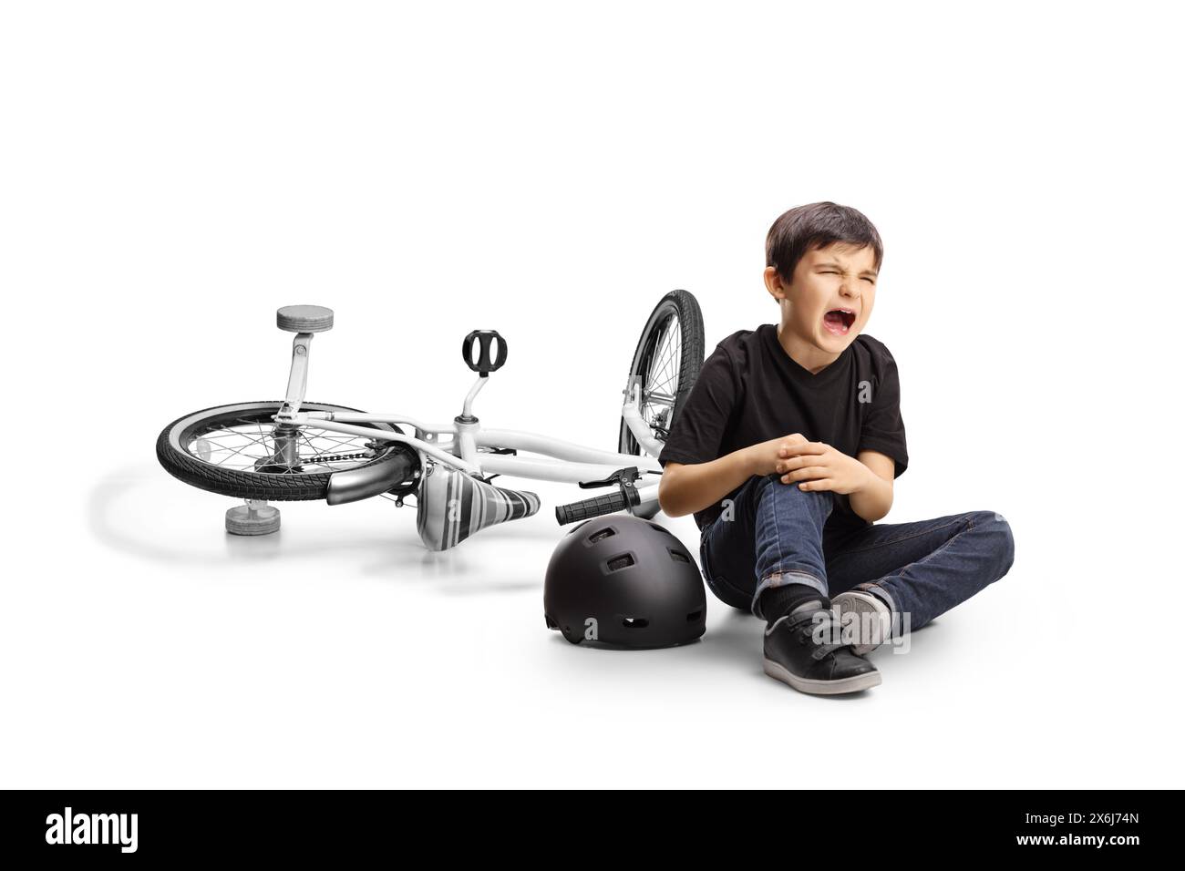Boy falling from a bicycle and holding his injured knee isolated on ...