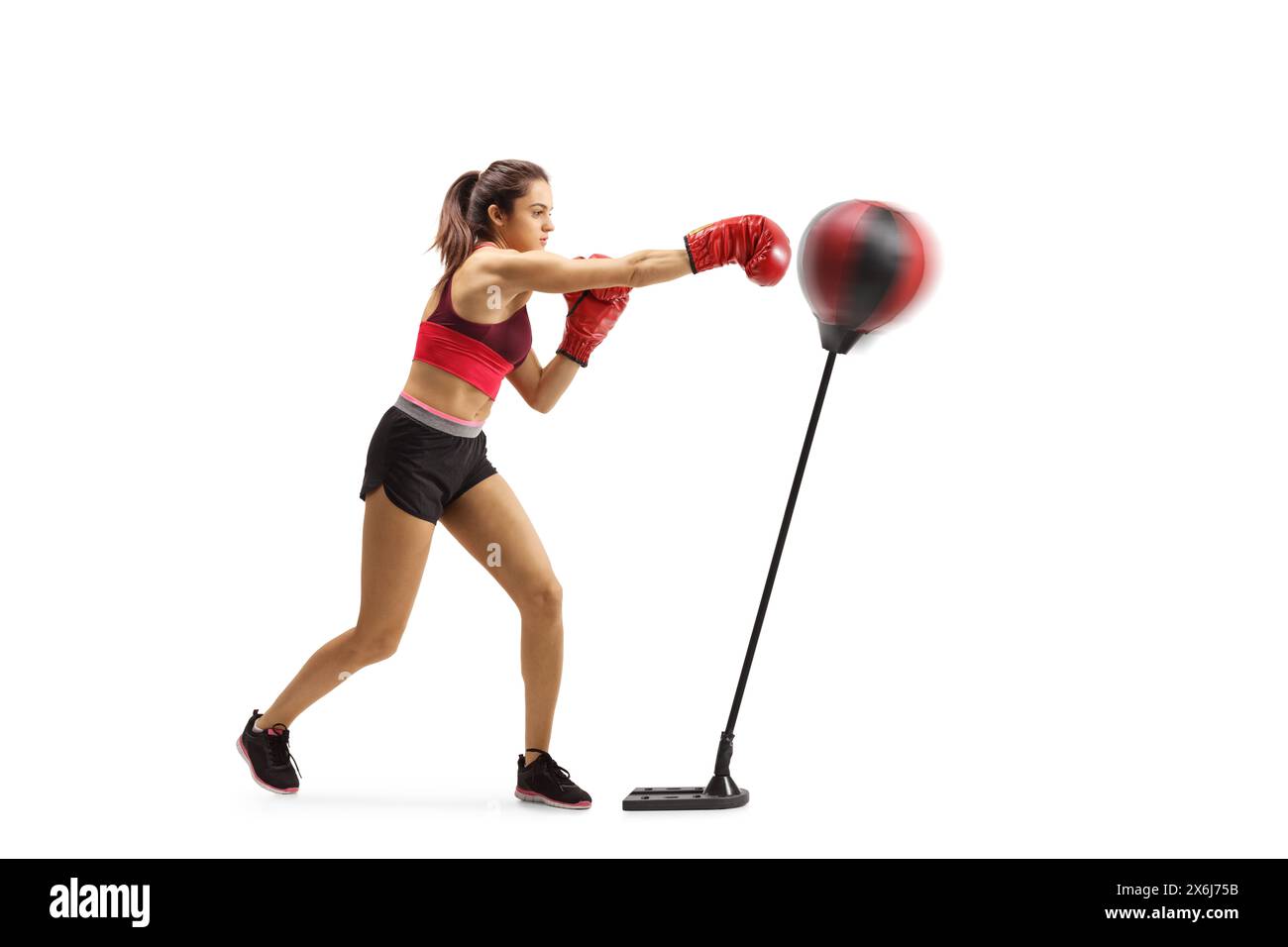 Full length profile shot of a young woman training box with a punch ...