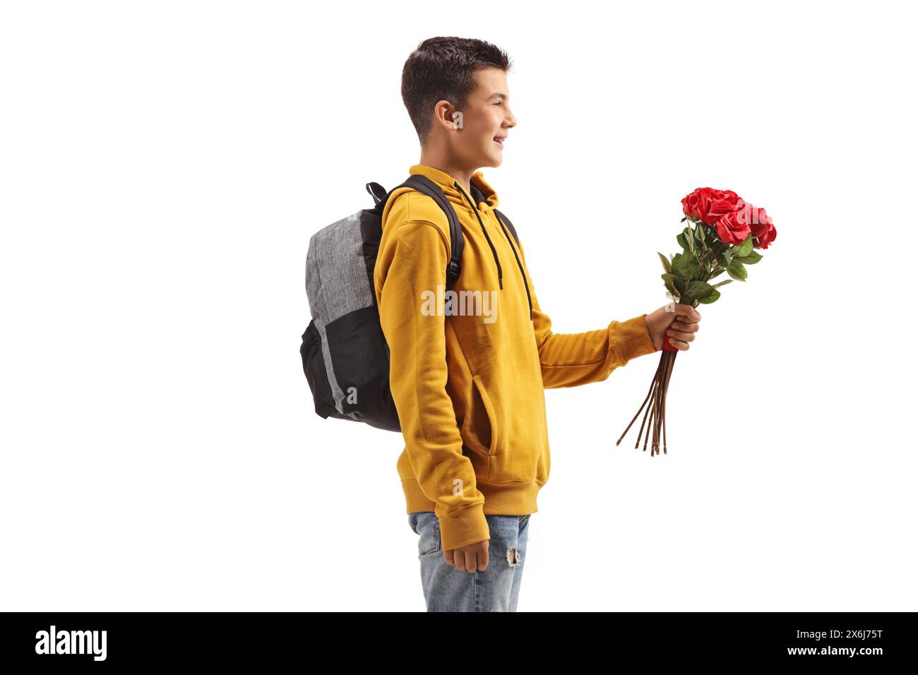 Profile shot of a male teenage student holding a bunch of red roses ...