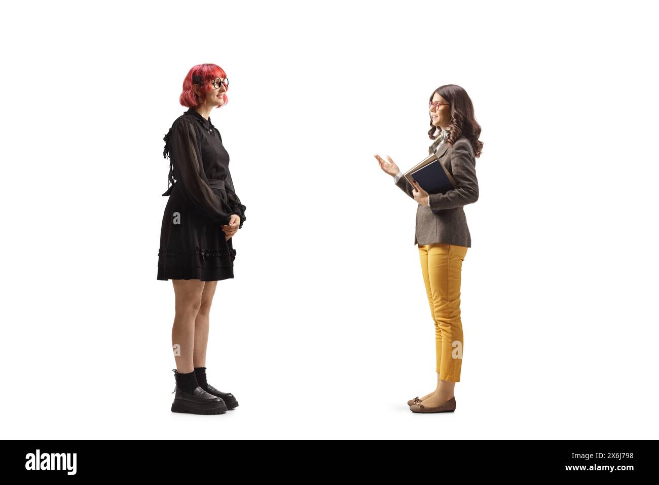 Full length profile shot of two young women talking isolated on white ...