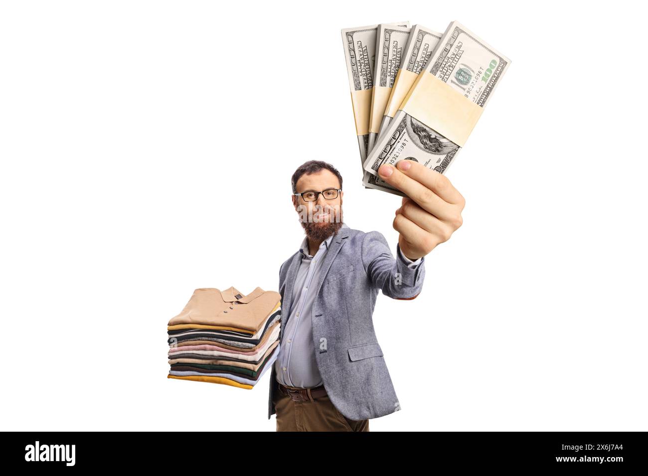Man with a pile of folded clothes smiling at camera and holding money ...
