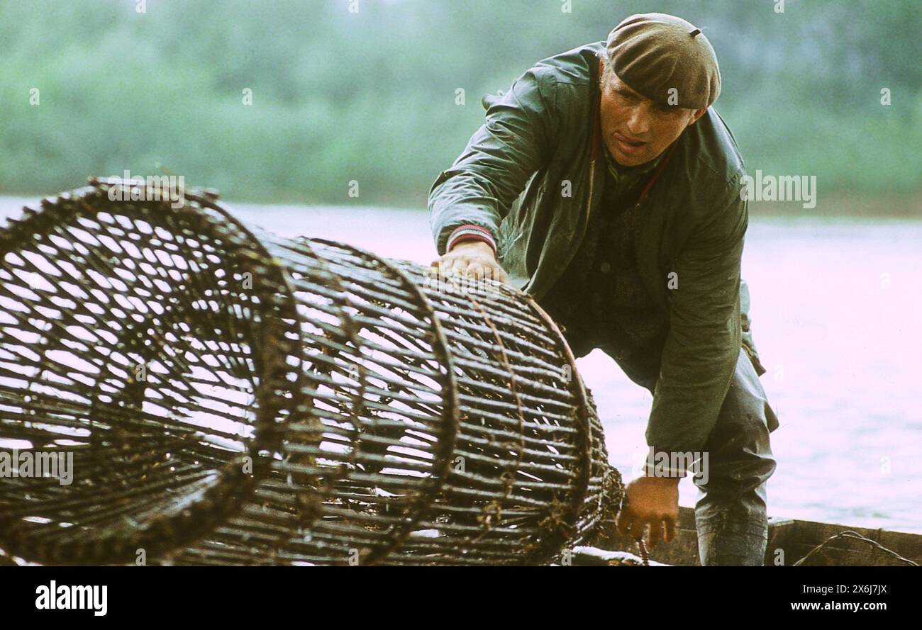 Socialist Republic of Romania in the 1970s. Fisherman on wooden boat ...